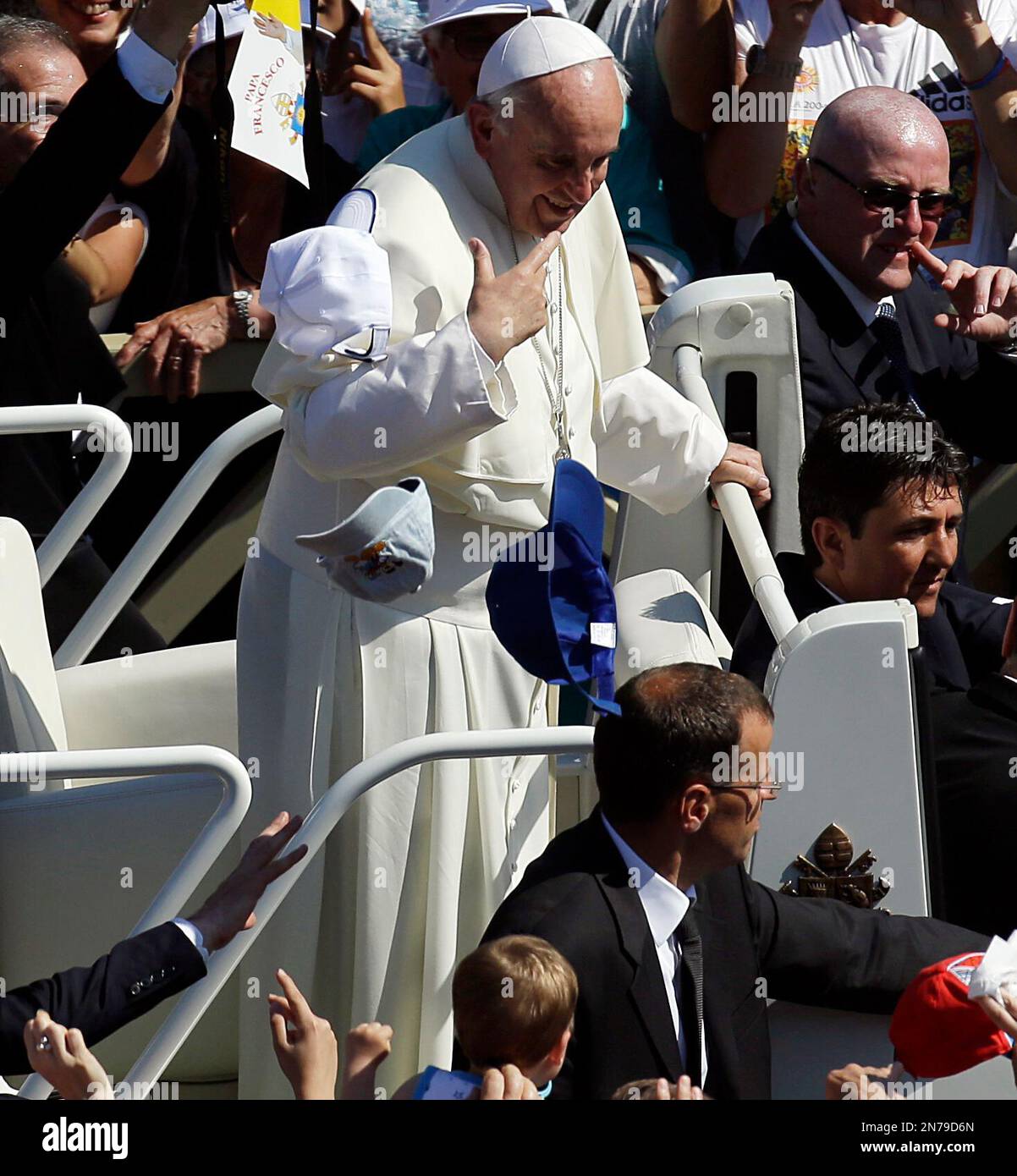 Faithful throw caps to Pope Francis as he arrives in St. Peter's Square ...