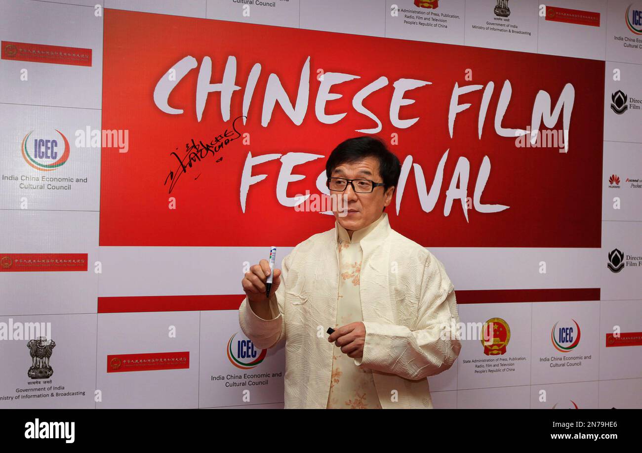 Chinese Hollywood actor Jackie Chan signs his autograph on a banner ...