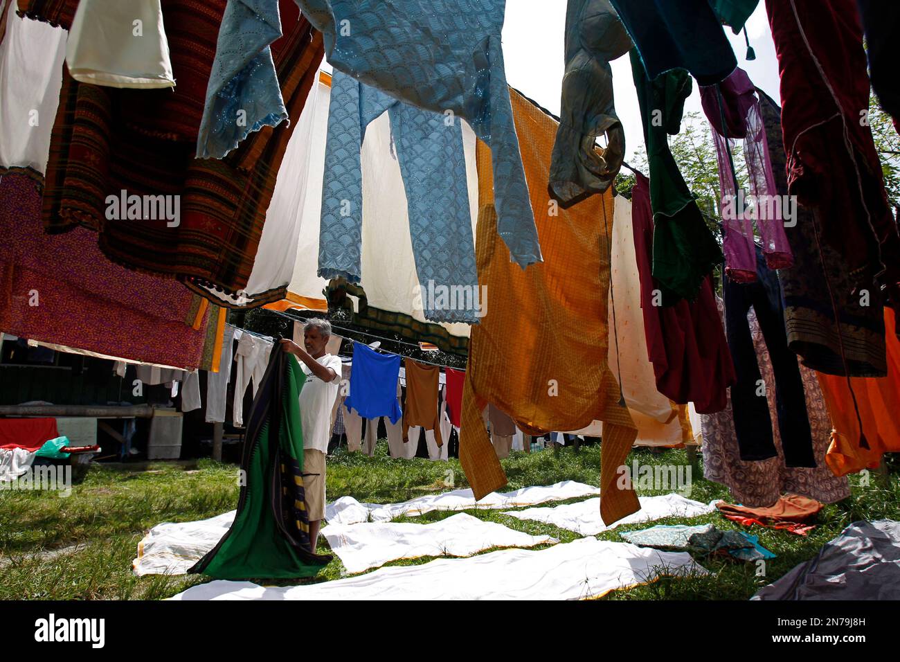 A worker brings in the laundry at a traditional laundry shop in Kuala ...