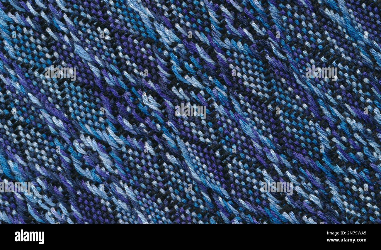 Handwoven fabric in black and blue shades with complicated pattern ...