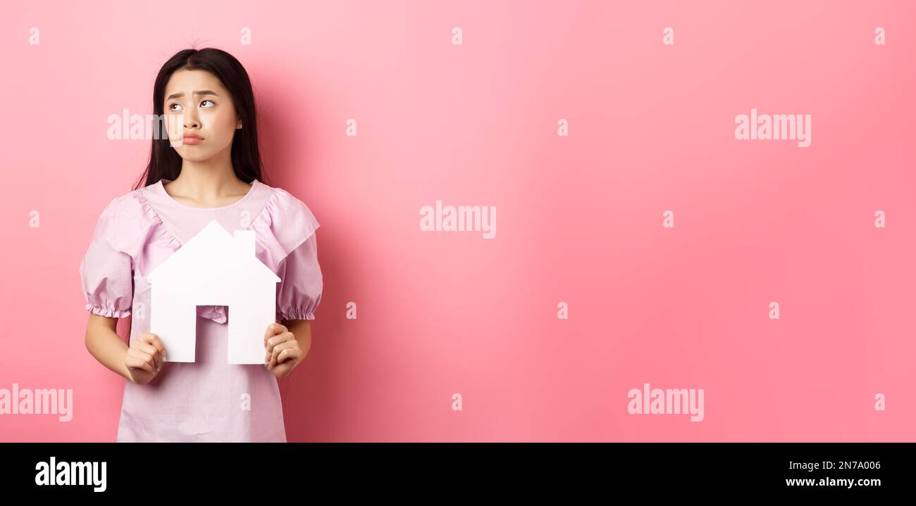 Real estate and insurance concept. Sad asian woman looking aside with ...