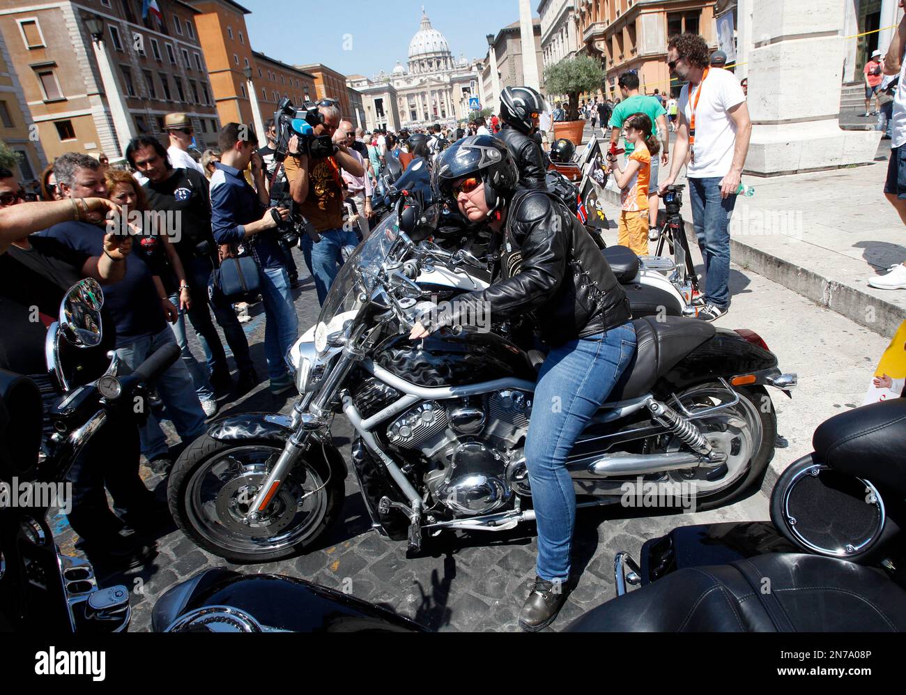 A Harley-Davidson rider sits on her motorcycle in front of St. Peter's ...