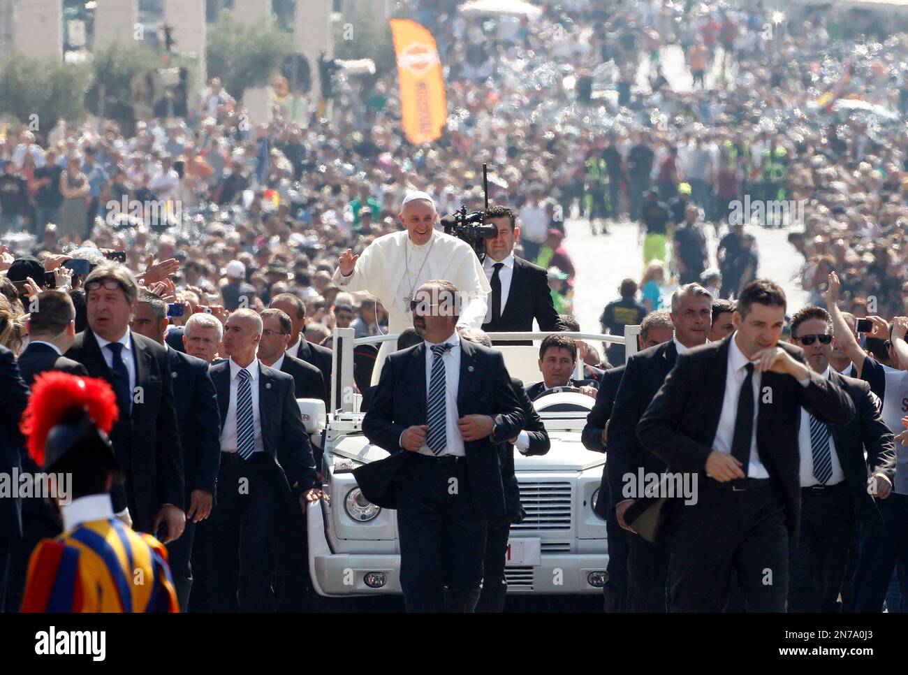 Security guards surround Pope Francis as he waves to faithful upon his ...