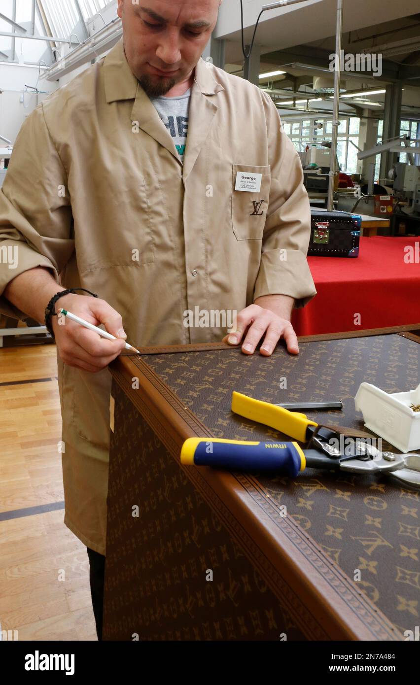 a working class to sew luxury leather suit case during a visit of ...