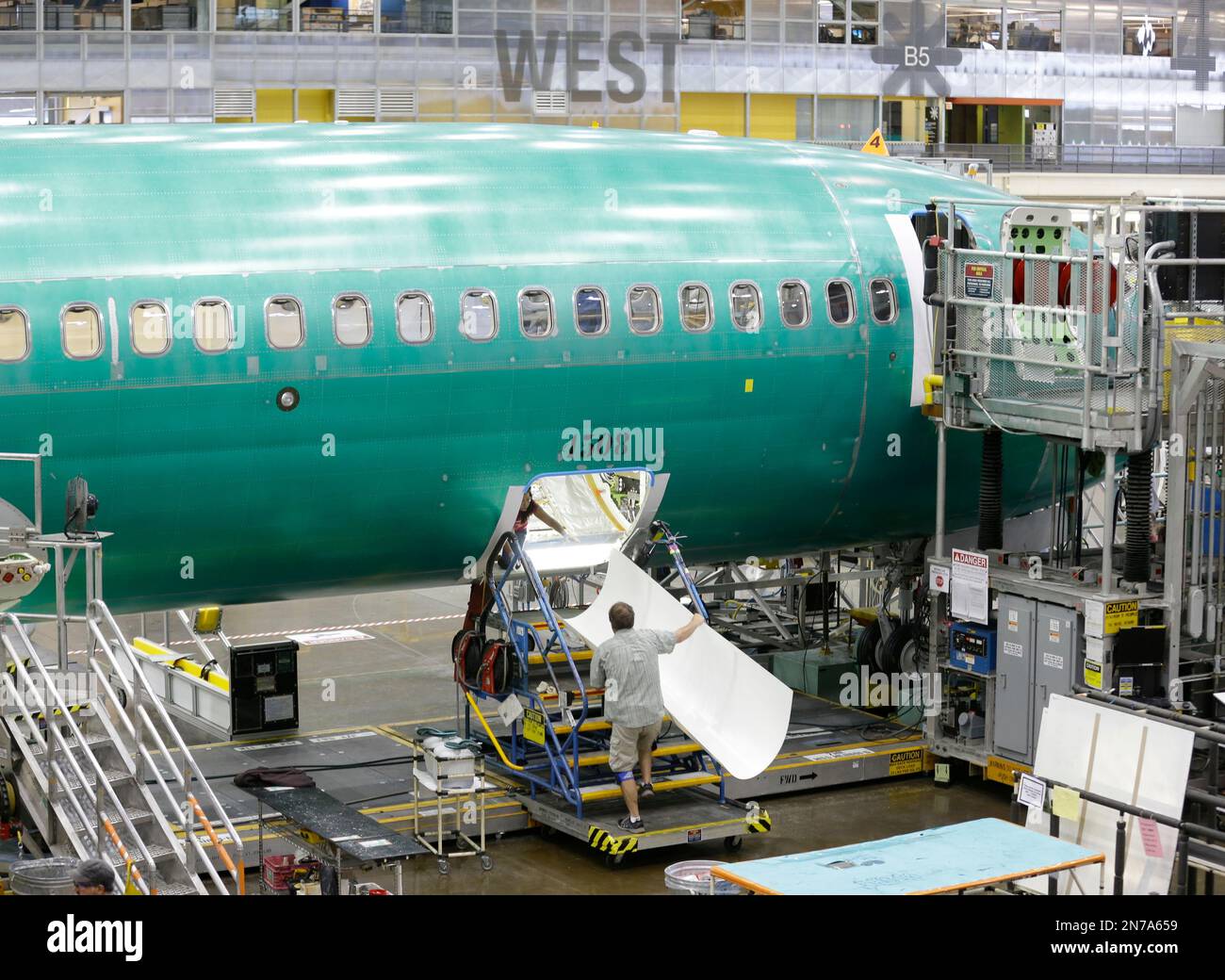 In this photo taken May 30, 2013, a Boeing employee carries material ...