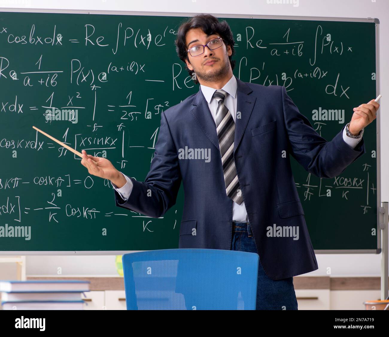 The young male math teacher in classroom Stock Photo - Alamy