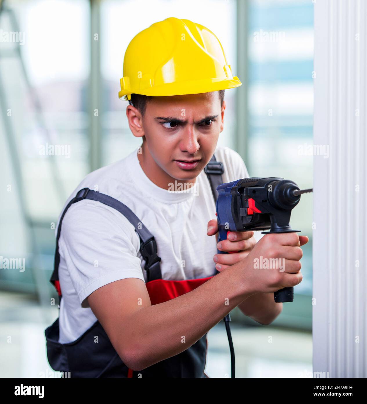 The man drilling the wall with drill perforator Stock Photo - Alamy