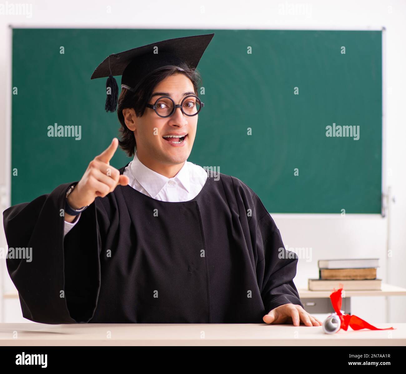 The graduate student in front of green board Stock Photo - Alamy