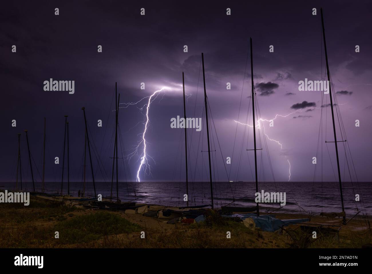 A Lightning over the ocean in front of Sail Boats Stock Photo - Alamy