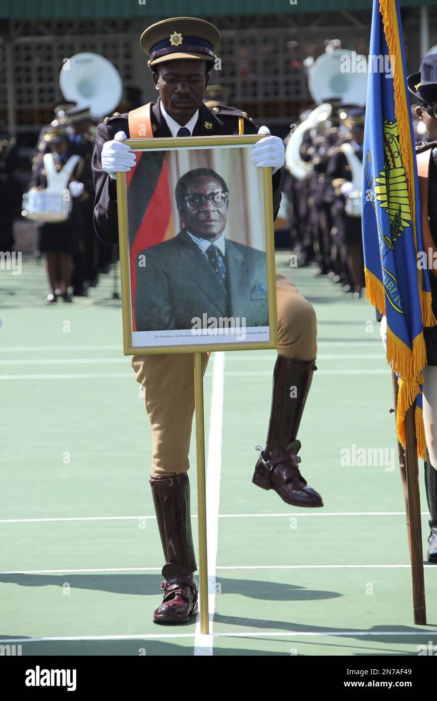 A police officer holds a portrait of President Robert Mugabe during an inspection of the guard ...