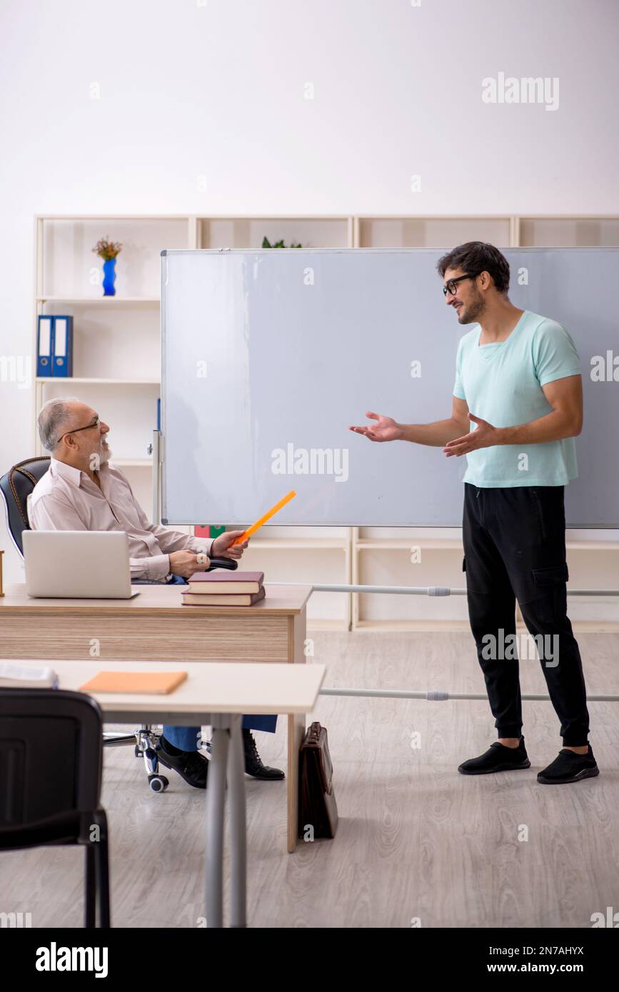 Old teacher and young student in the classroom Stock Photo - Alamy