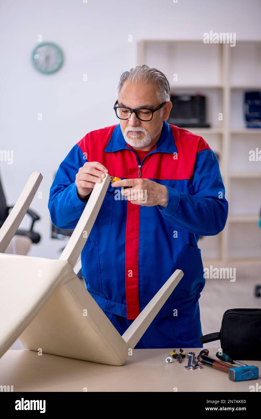 Old carpenter repairing chair at home Stock Photo - Alamy