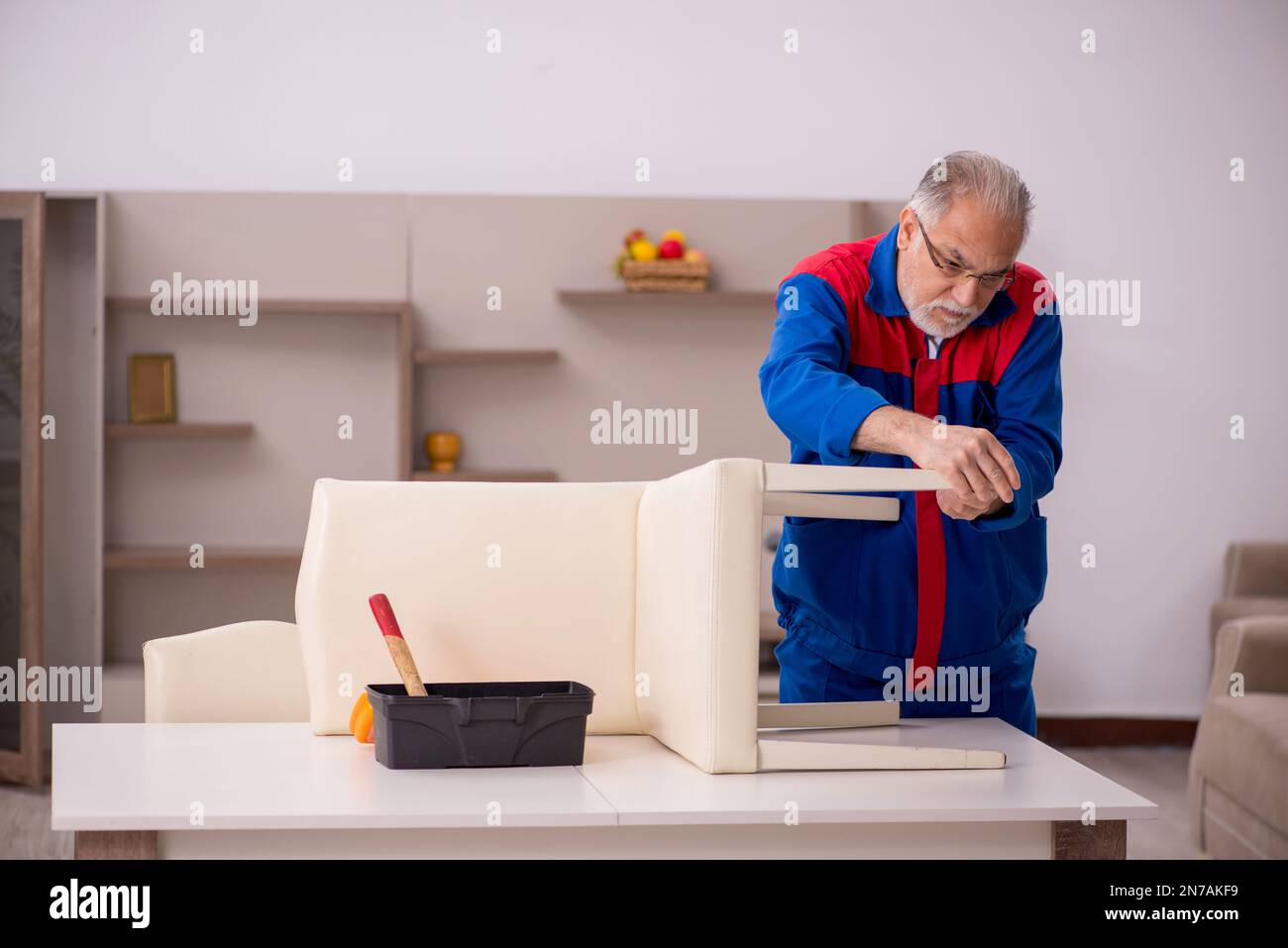 Old carpenter repairing chair at home Stock Photo - Alamy