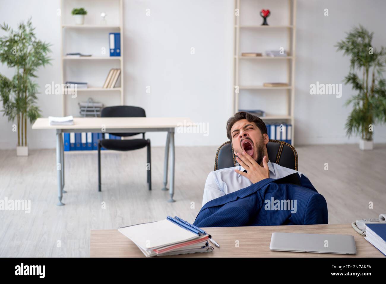 Young businessman employee extremely tired at workplace Stock Photo - Alamy