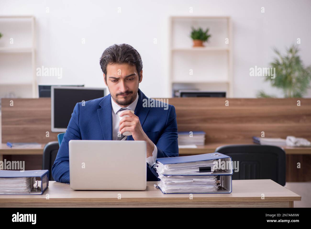Young employee drinking coffee during break Stock Photo - Alamy