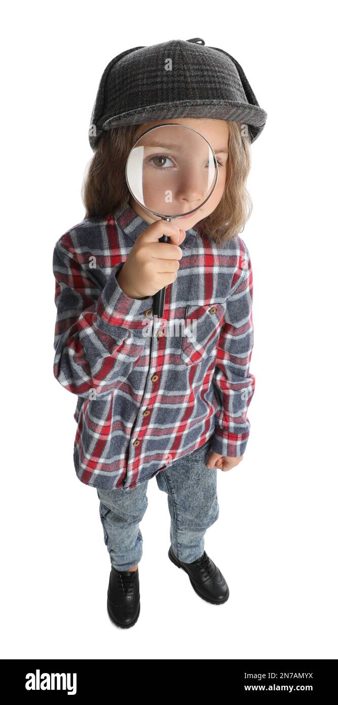 Cute little child in hat with magnifying glass playing detective on ...