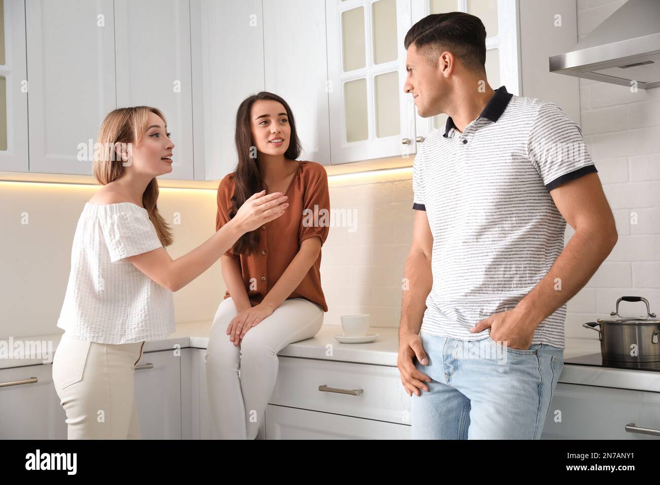 Group of people having conversation in kitchen Stock Photo - Alamy