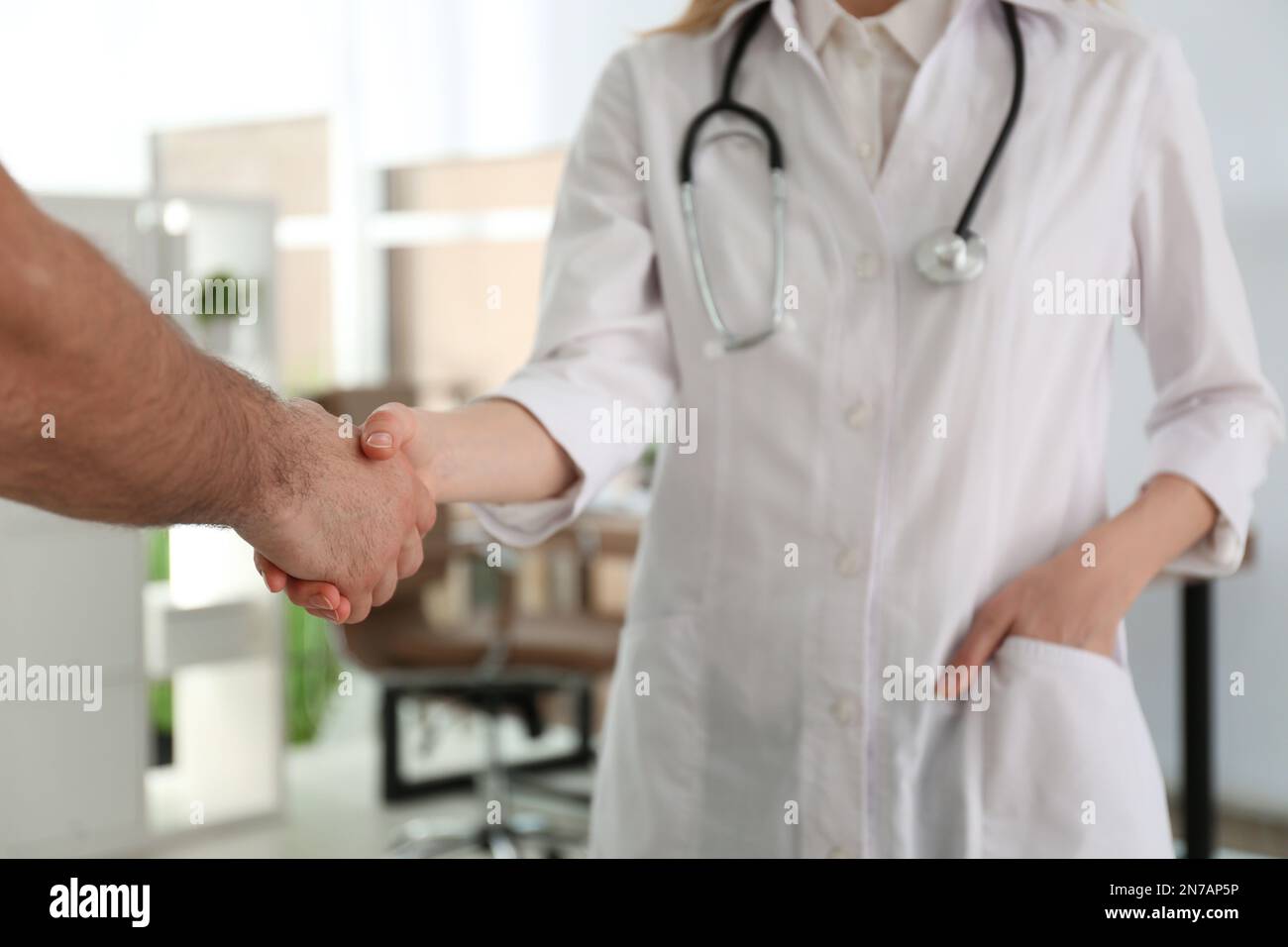 Doctor and patient shaking hands in clinic, closeup Stock Photo - Alamy