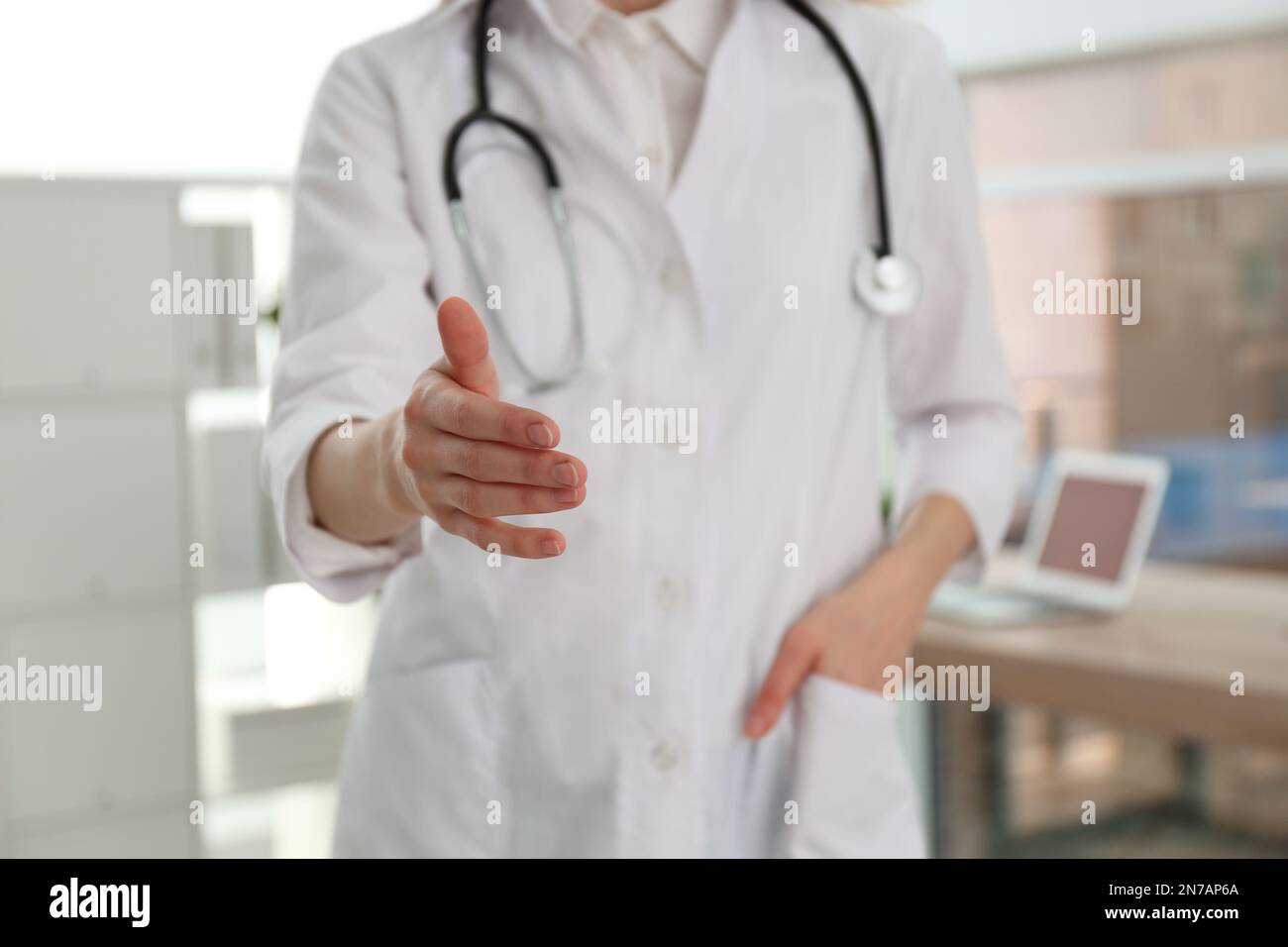 Female doctor offering handshake in clinic, closeup Stock Photo - Alamy