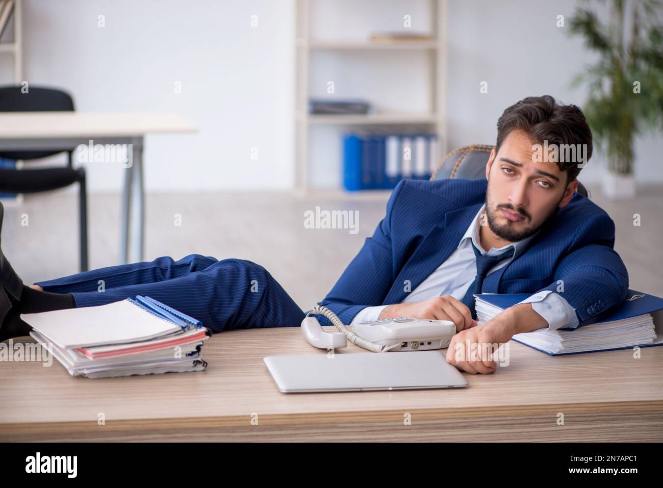 Young businessman employee extremely tired at workplace Stock Photo - Alamy