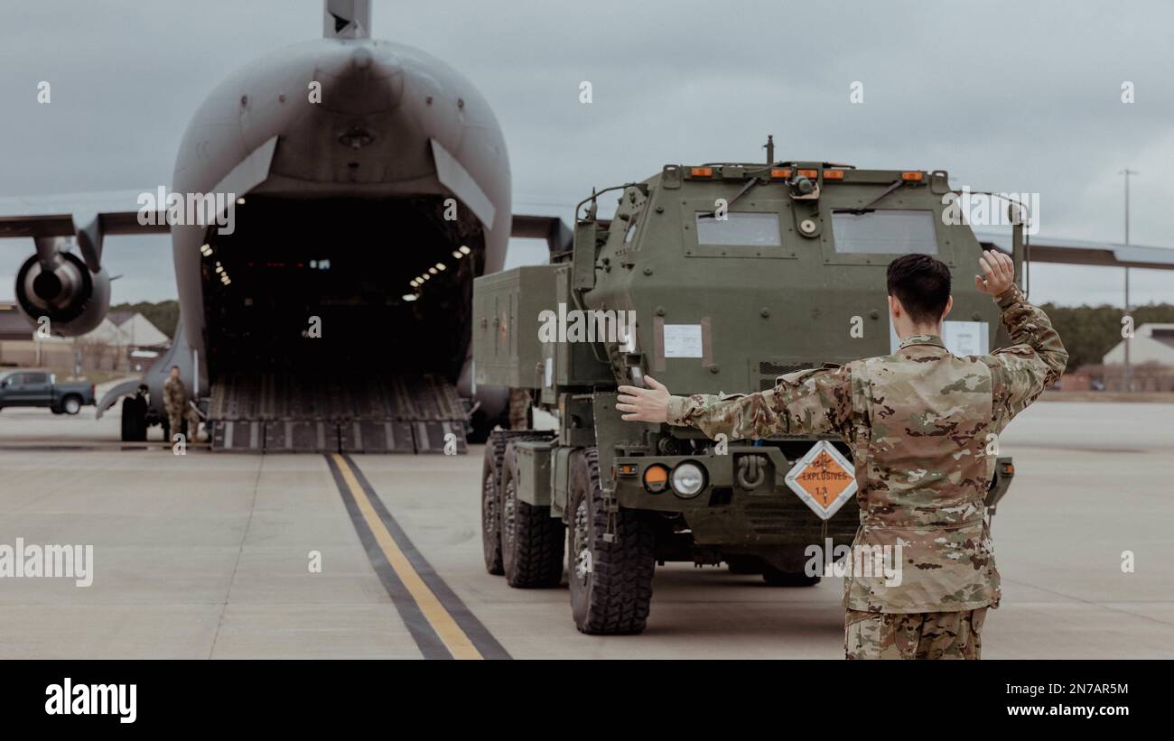 A U.S. Airman guides a M142 High Mobility Artillery Rocket System onto ...
