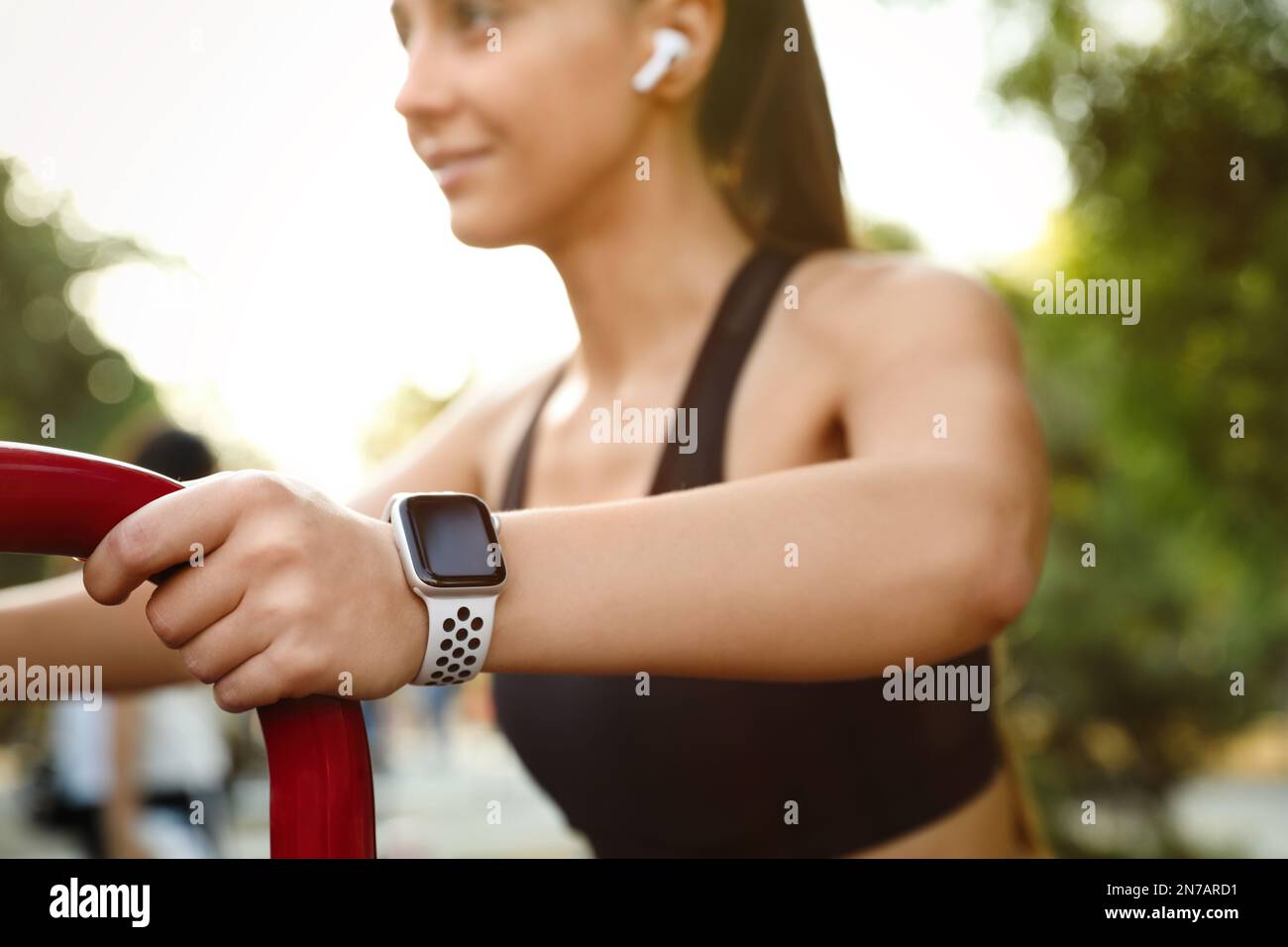 Smiling sportive young woman outdoors watch hi-res stock photography ...