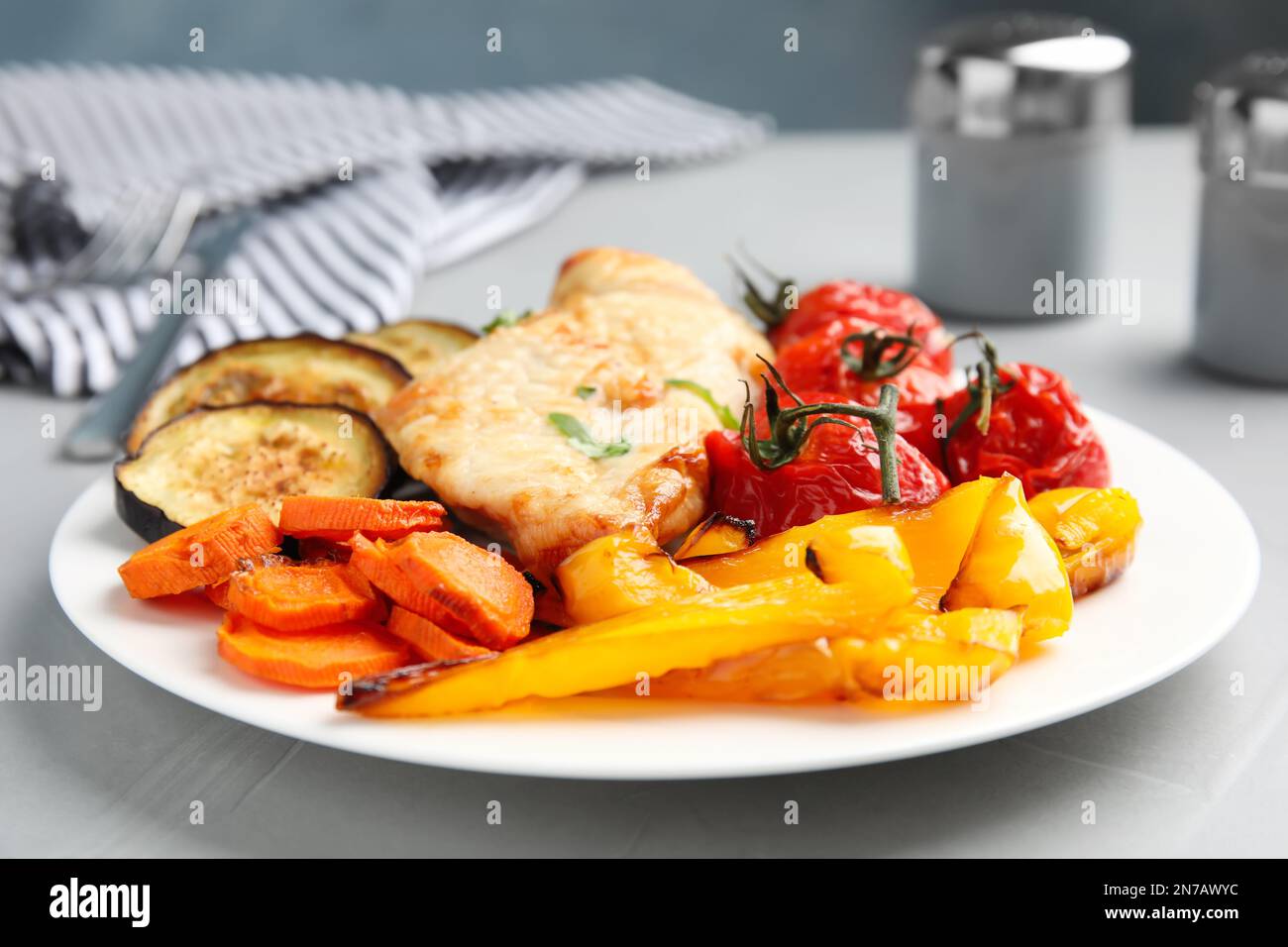 Delicious cooked chicken and vegetables on grey table, closeup. Healthy ...