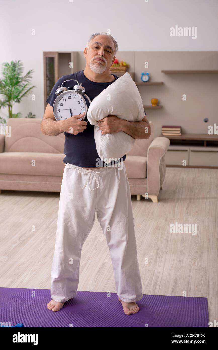 Old man doing sport exercises indoors Stock Photo - Alamy