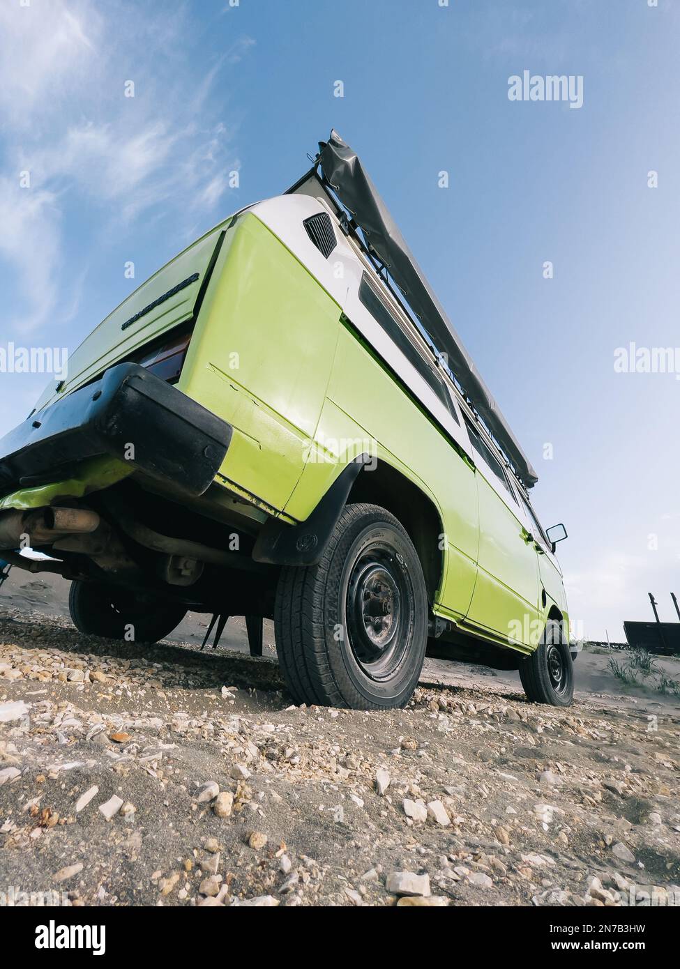Green van stands on a rocky beach. Bottom view Stock Photo - Alamy
