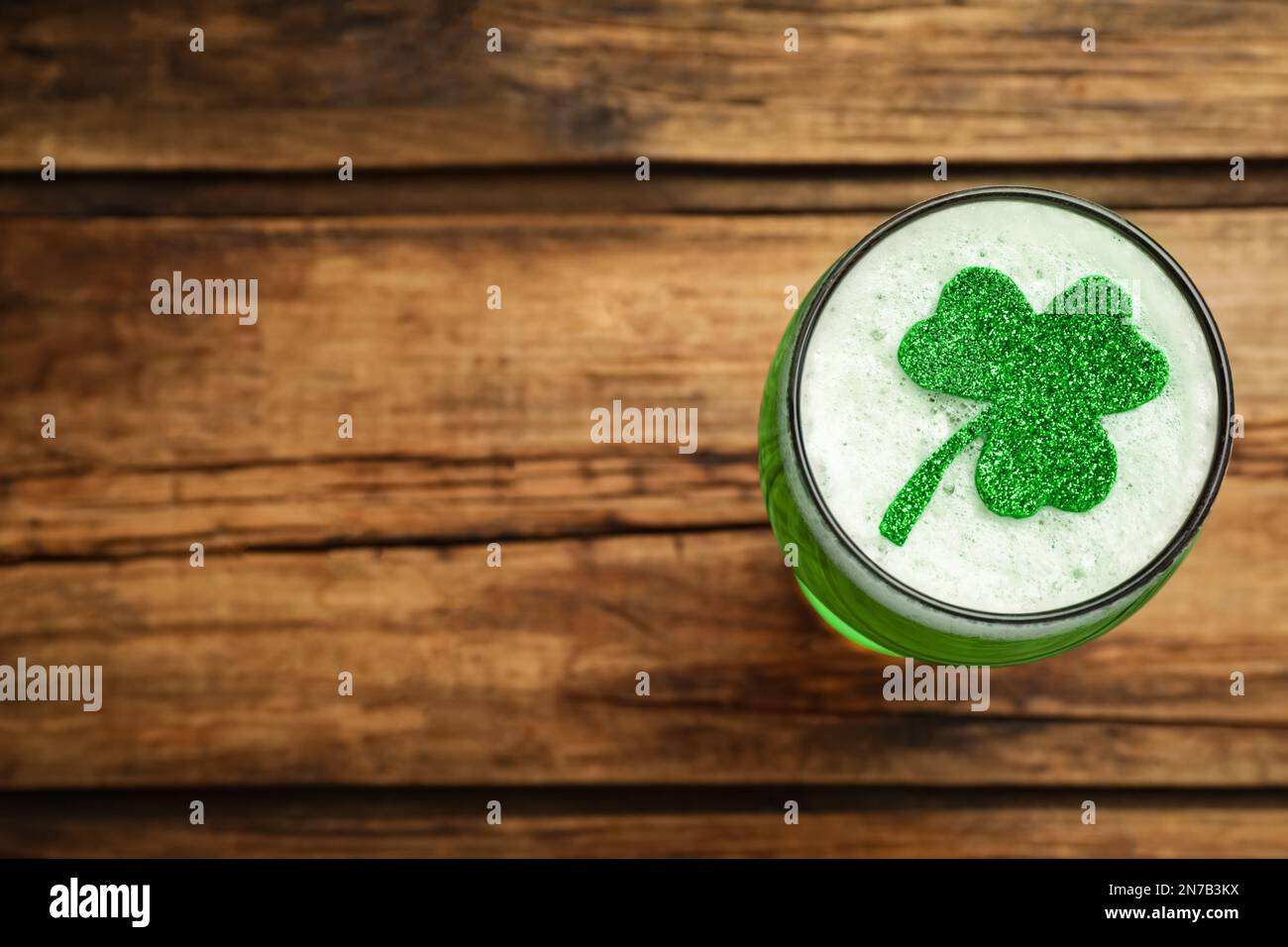 Top view of beer with clover leaf on wooden table, space for text. St ...