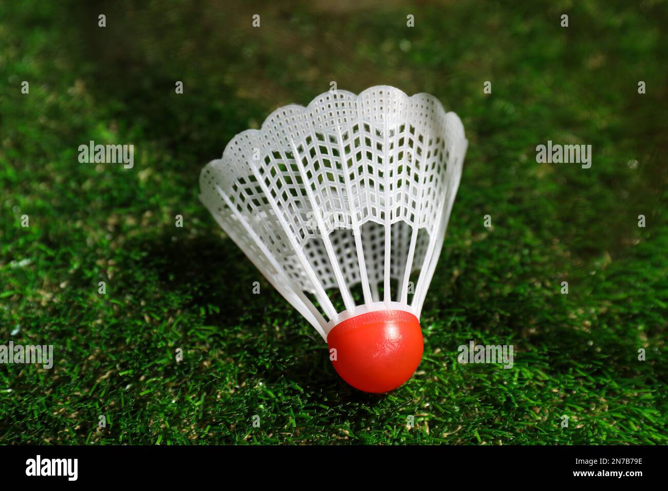Plastic shuttlecock on artificial grass, closeup. Badminton equipment ...