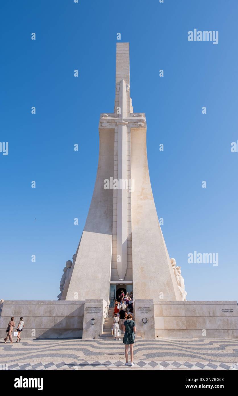 A tourist with her back to the entrance of the monument to the ...