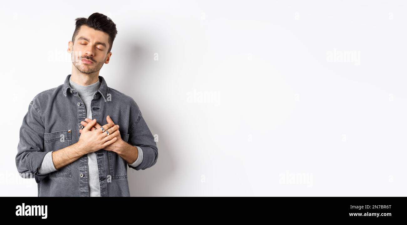 Nostalgic man hold hands on heart, remember tender memories, standing ...