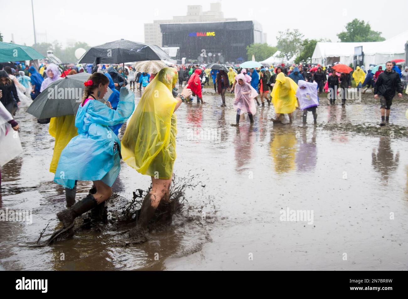 Concertgoers walk through a field of mud at the rain soaked 3rd annual ...
