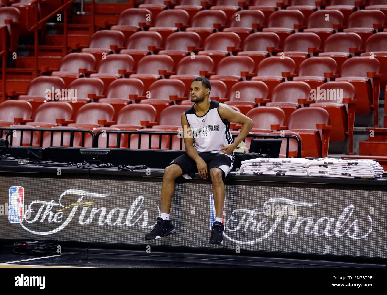 San Antonio Spurs point guard Patty Mills sits on the scorer's table ...