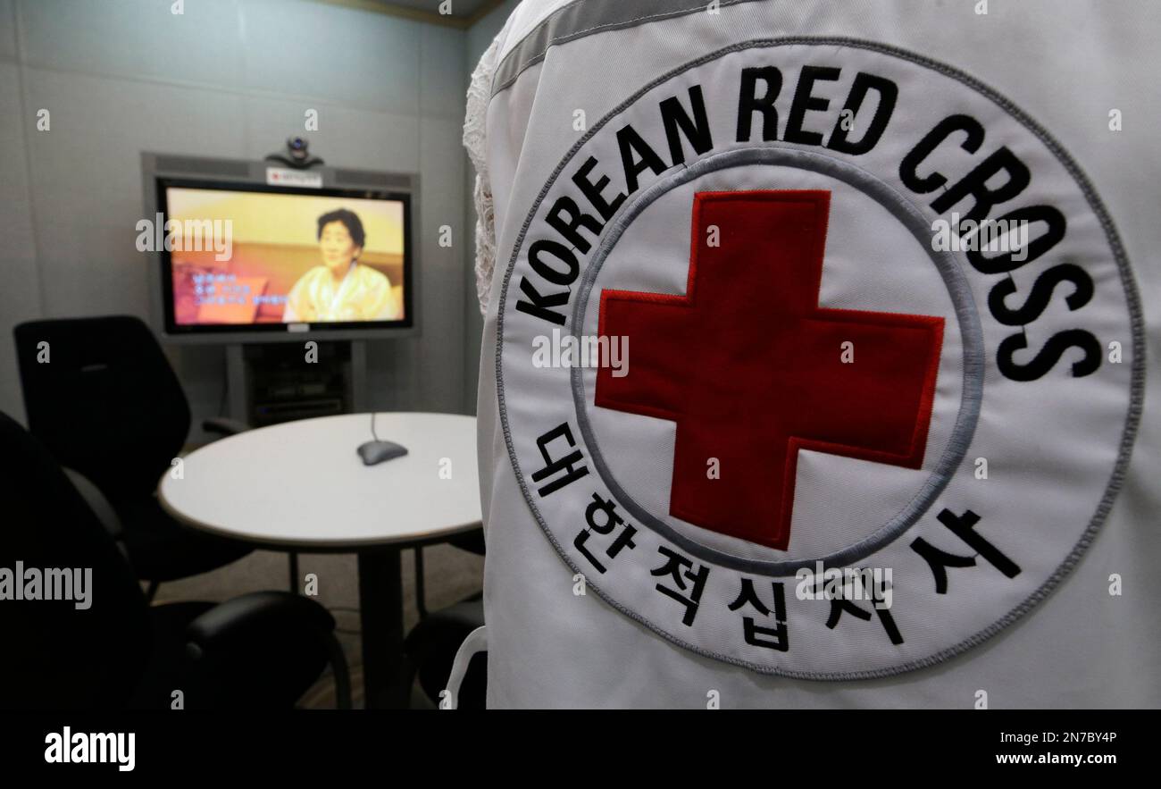 A South Korean Red Cross' employee stands near a display which shows a ...
