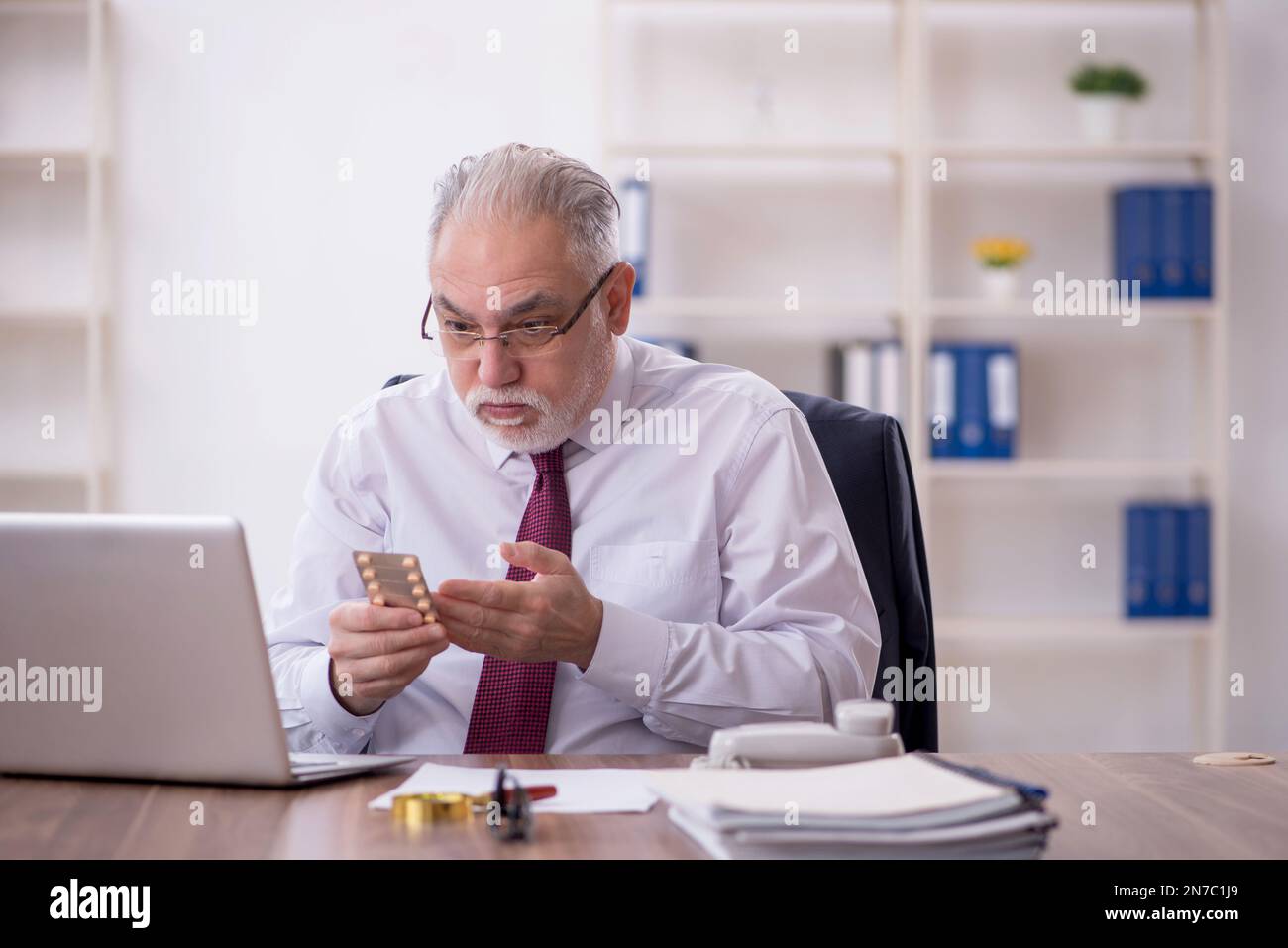 Old male employee feeling bad at workplace Stock Photo - Alamy