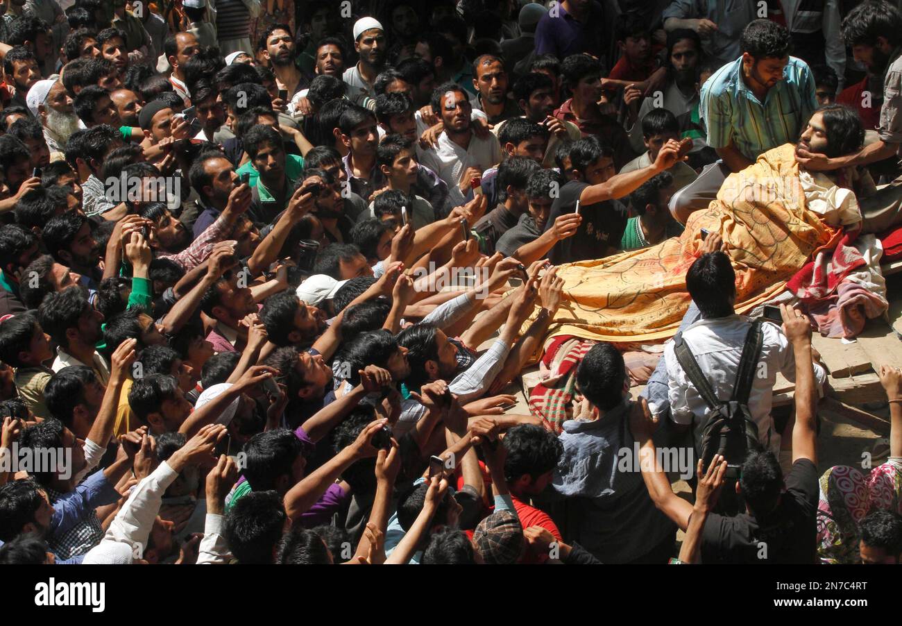 Kashmiri villagers take pictures with their cellphone cameras of the ...