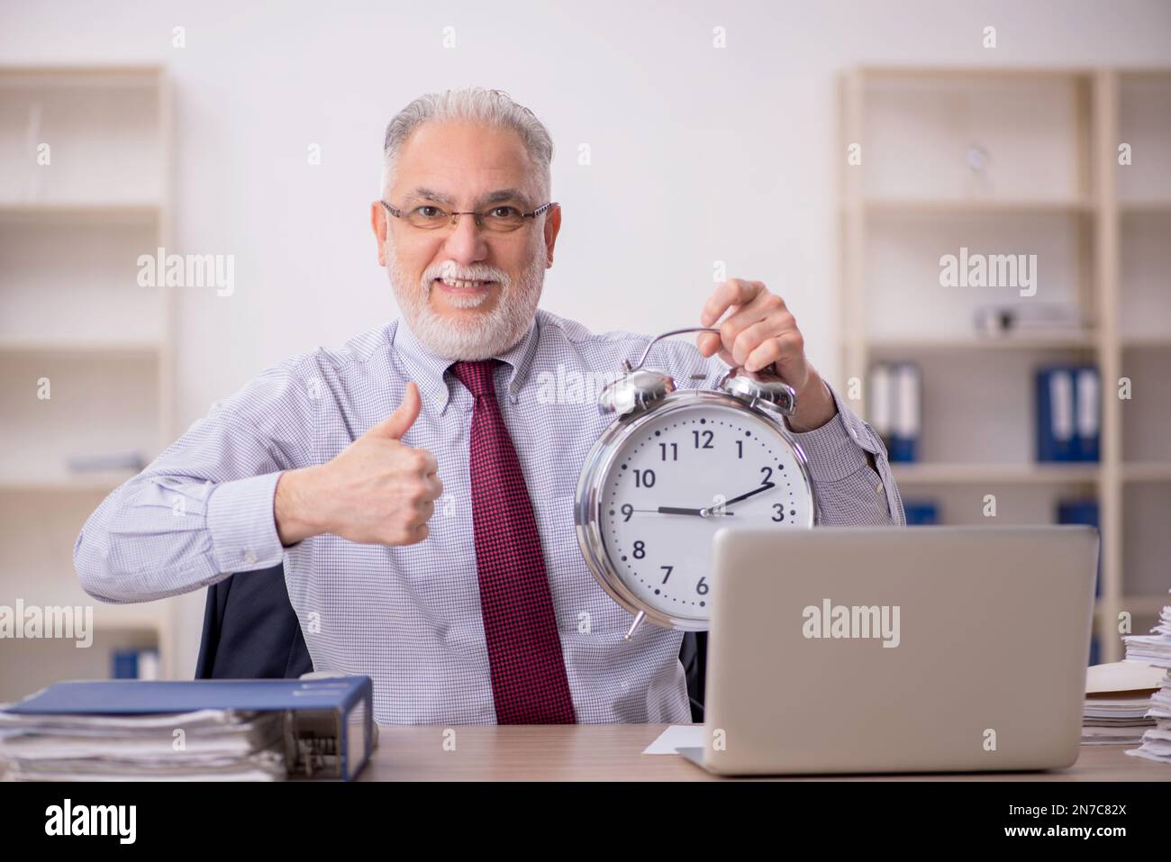 Old boss employee in time management concept Stock Photo - Alamy