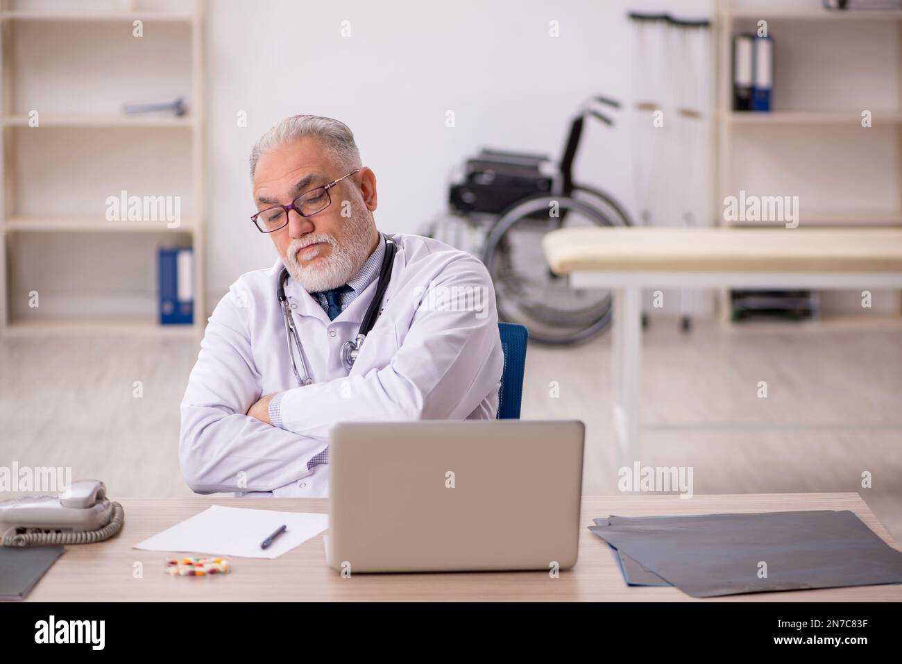 Old doctor working in the clinic Stock Photo - Alamy