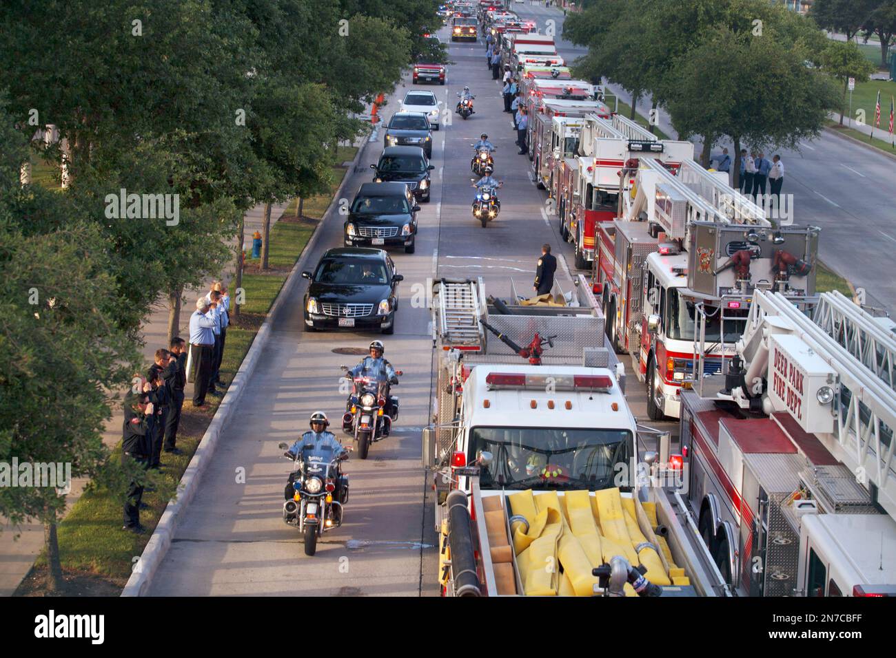 Firefighter's salute arriving families before a memorial procession Wednesday, June 5, 2013 in ...