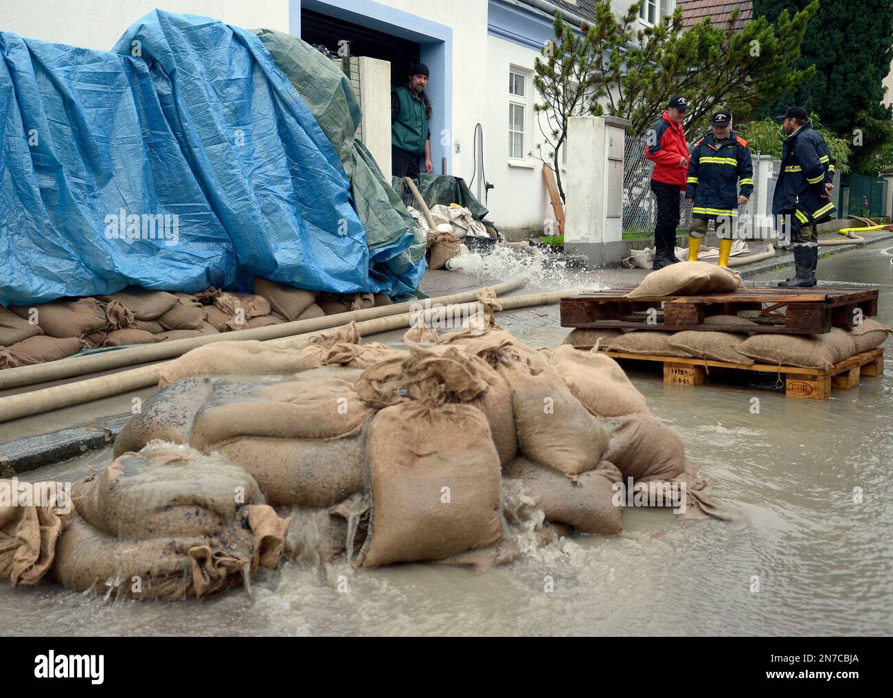 Firefighters pump water out of a building in Kritzendorf near Vienna ...