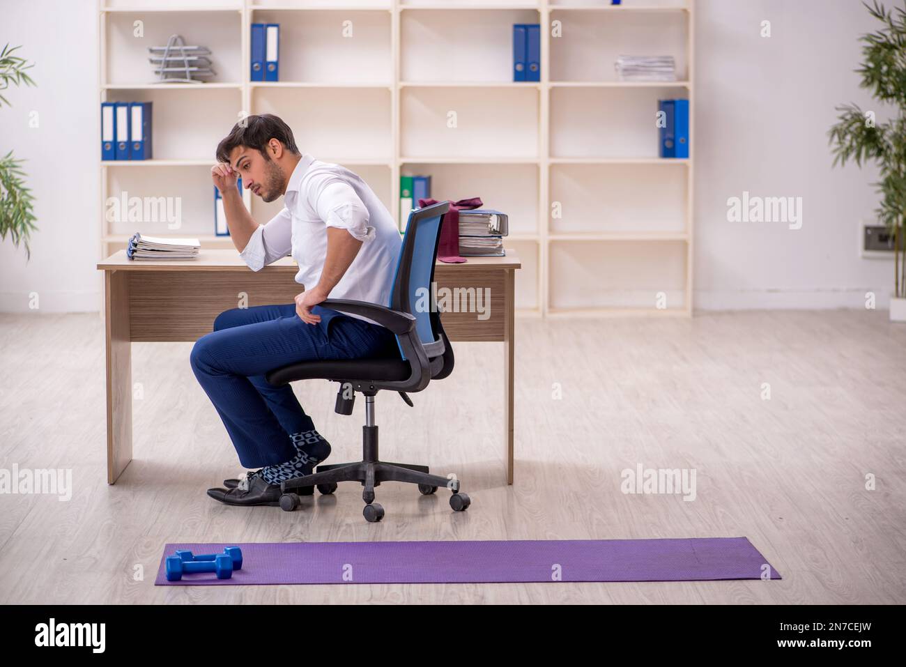 Young employee doing sport exercises during break Stock Photo - Alamy
