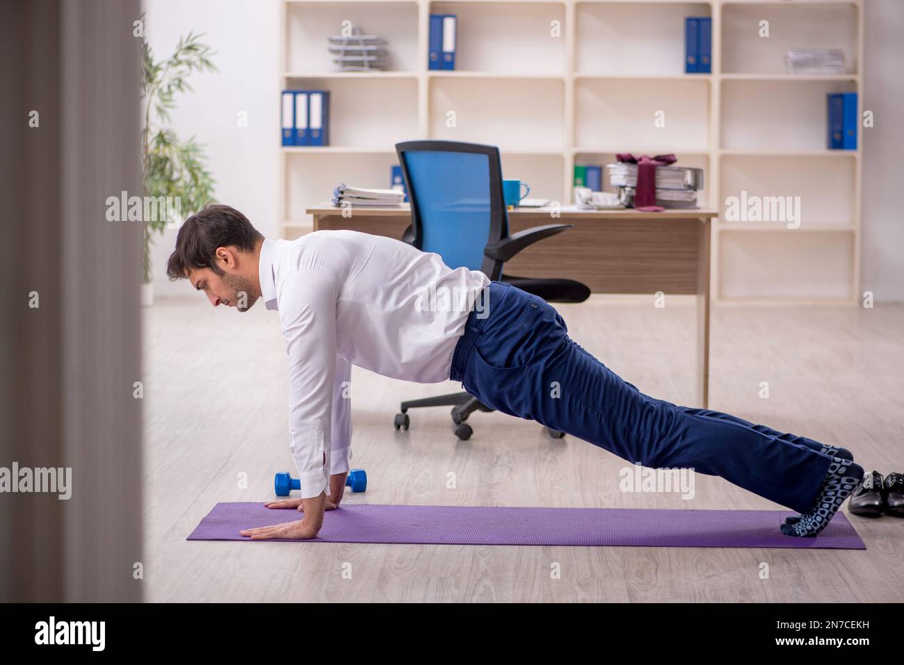 Young employee doing sport exercises during break Stock Photo - Alamy