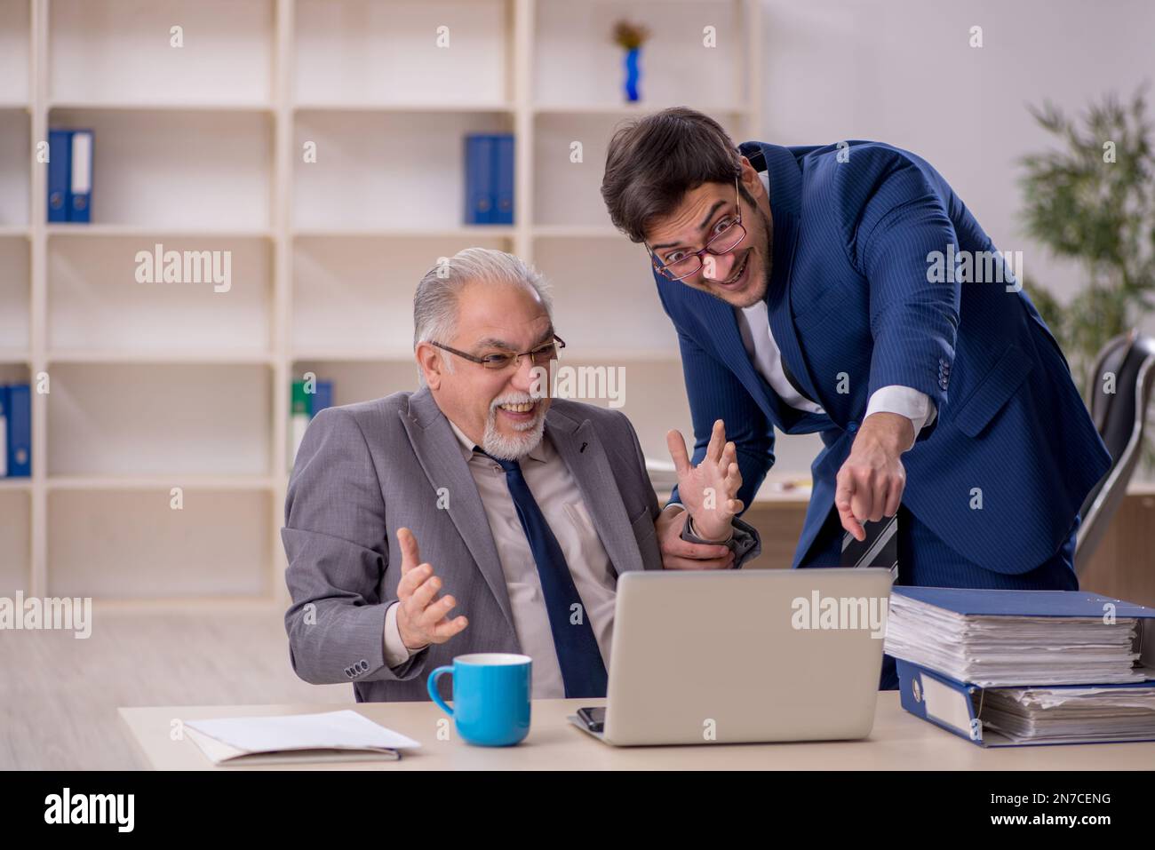 Old boss and young employee in the office Stock Photo - Alamy