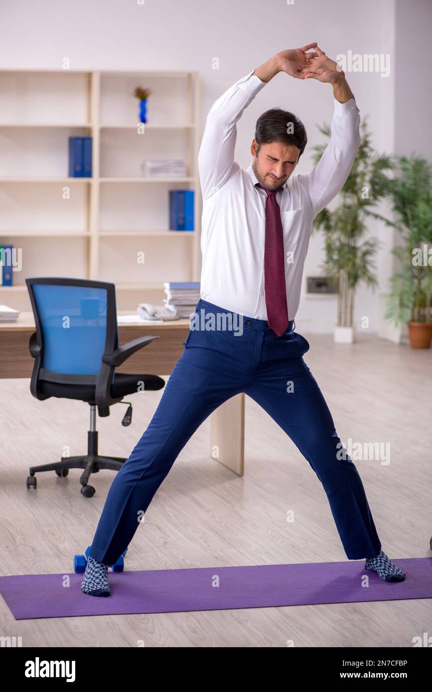 Young employee doing sport exercises during break Stock Photo - Alamy