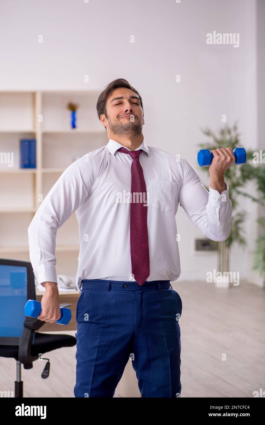 Young employee doing sport exercises during break Stock Photo - Alamy