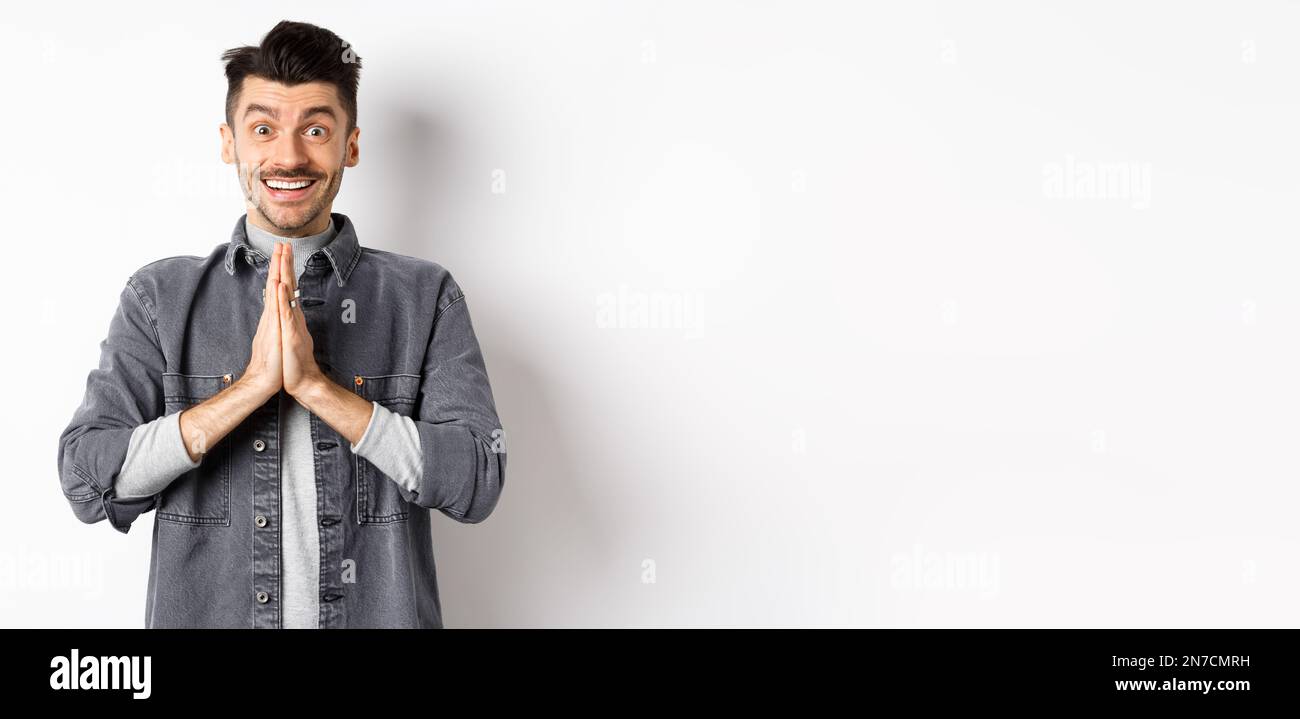 Please help me. Smiling cute man holding hands in namaste gesture ...