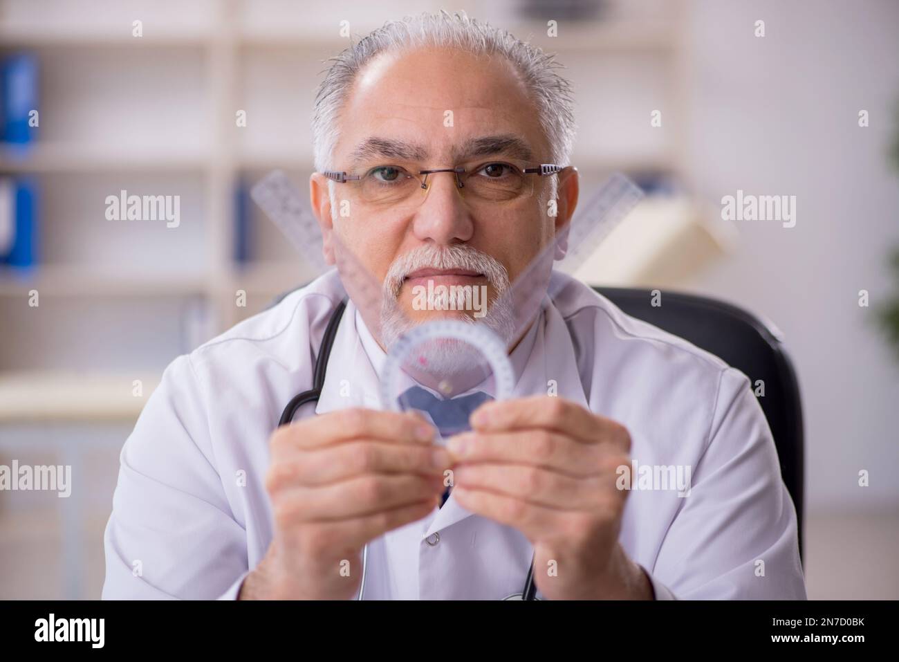 Old doctor holding goniometer at the hospital Stock Photo - Alamy