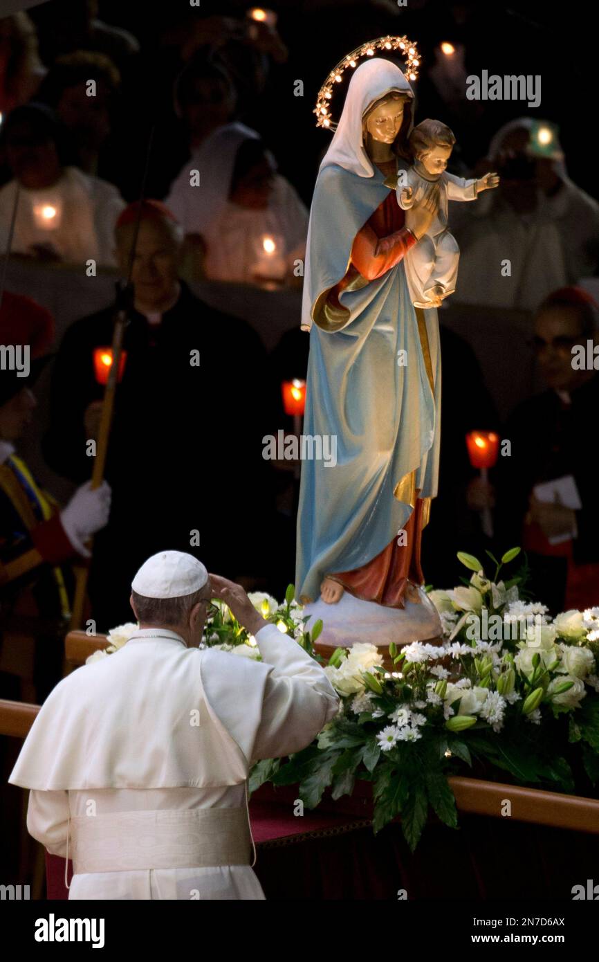 Pope Francis pays homage to a statue of the Virgin Mary during a ...